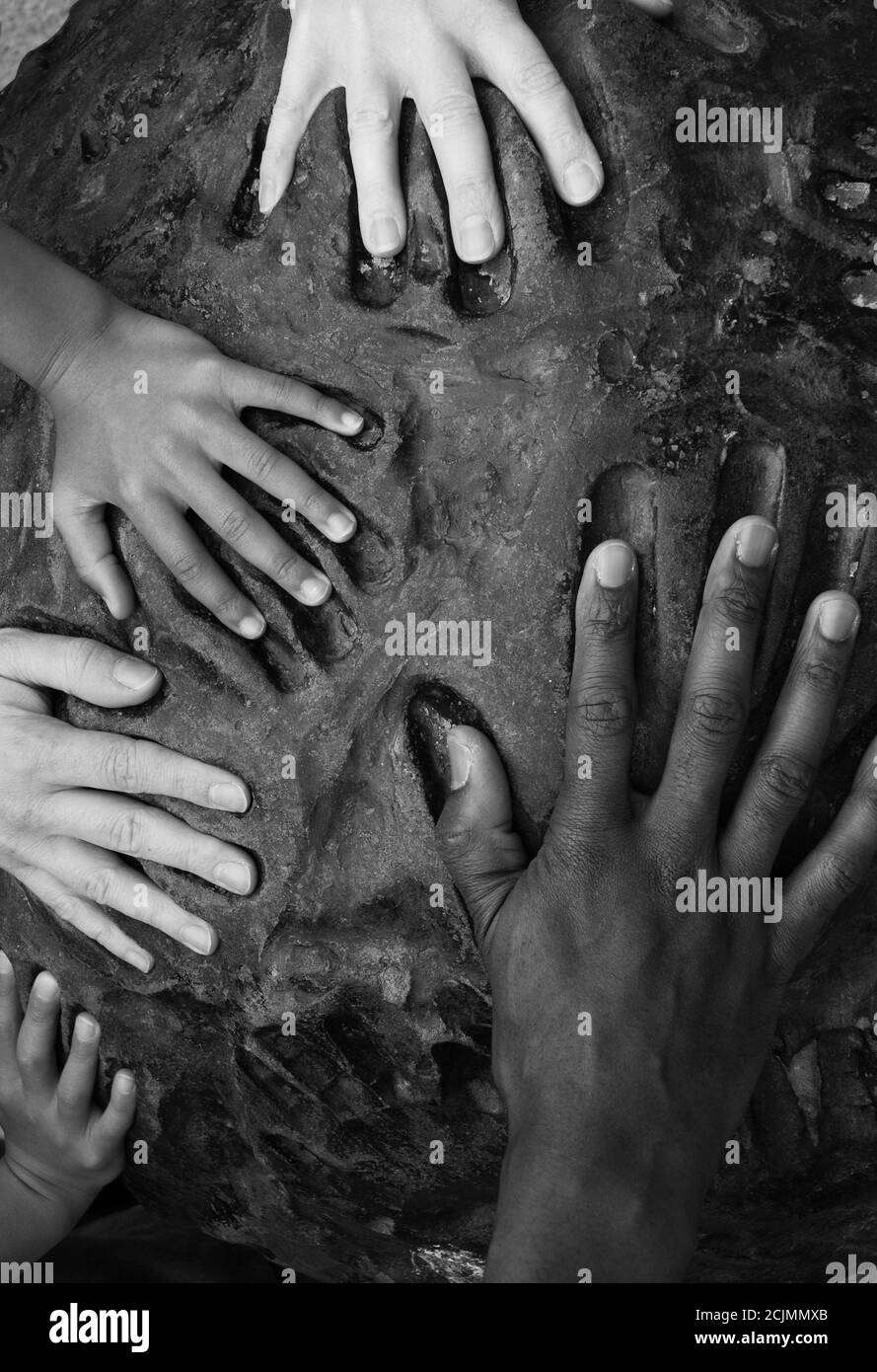 Multiple hands of different races fit into hand-prints on a piece of ...