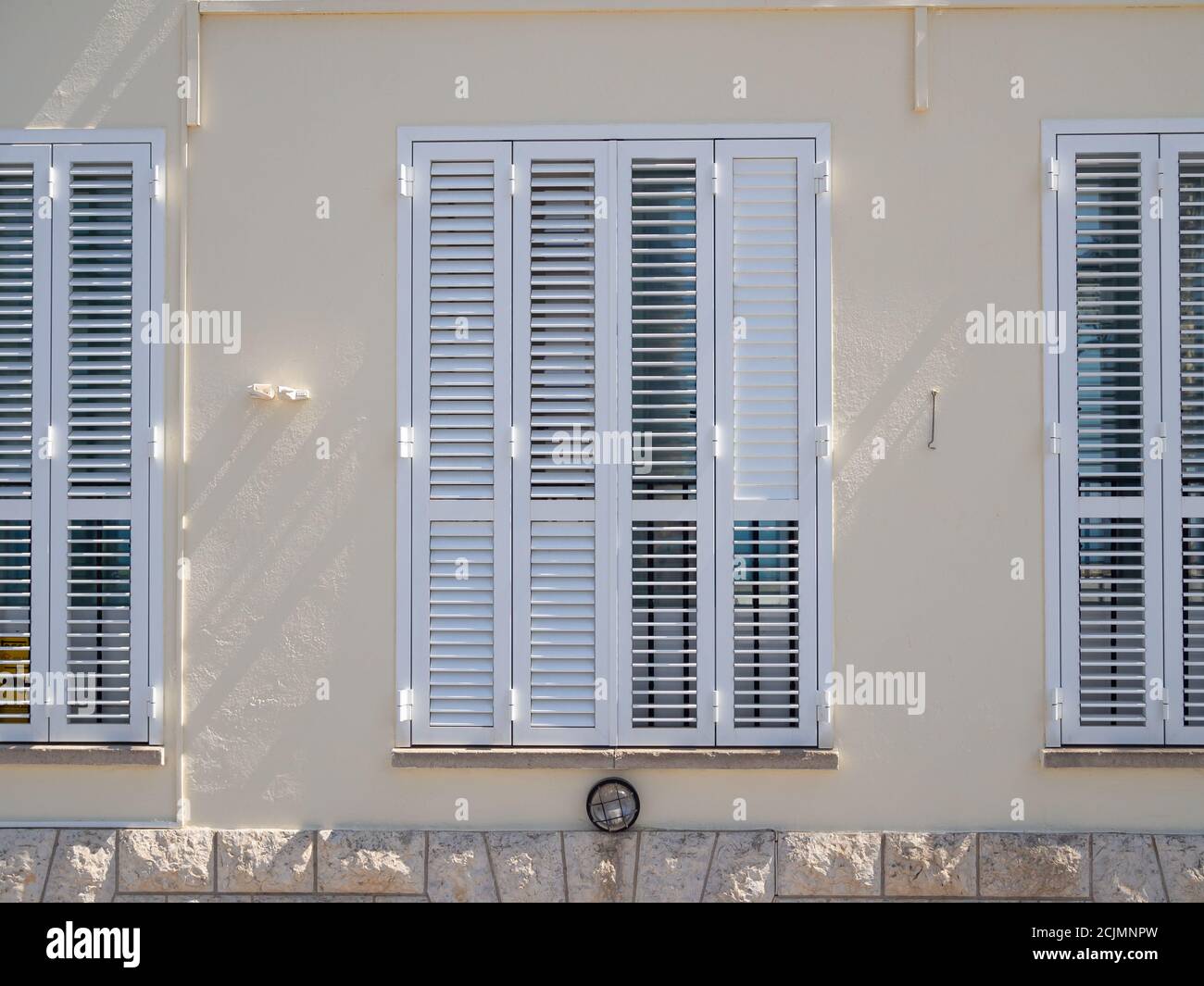 Mediterranean wooden window with shutters in the yellow house wall ...