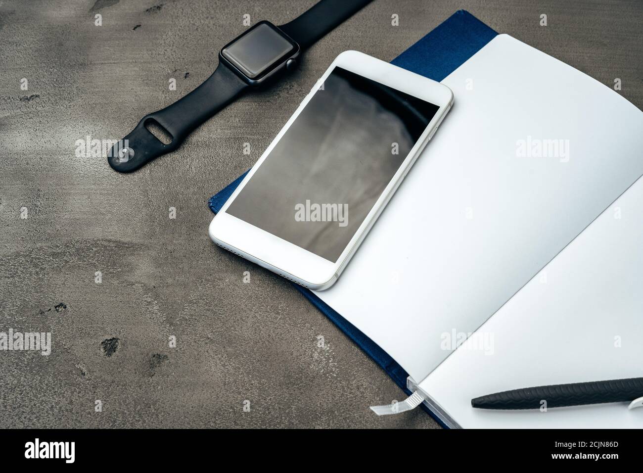 Open notepad, smartphone and smart watch on dark grey background Stock ...