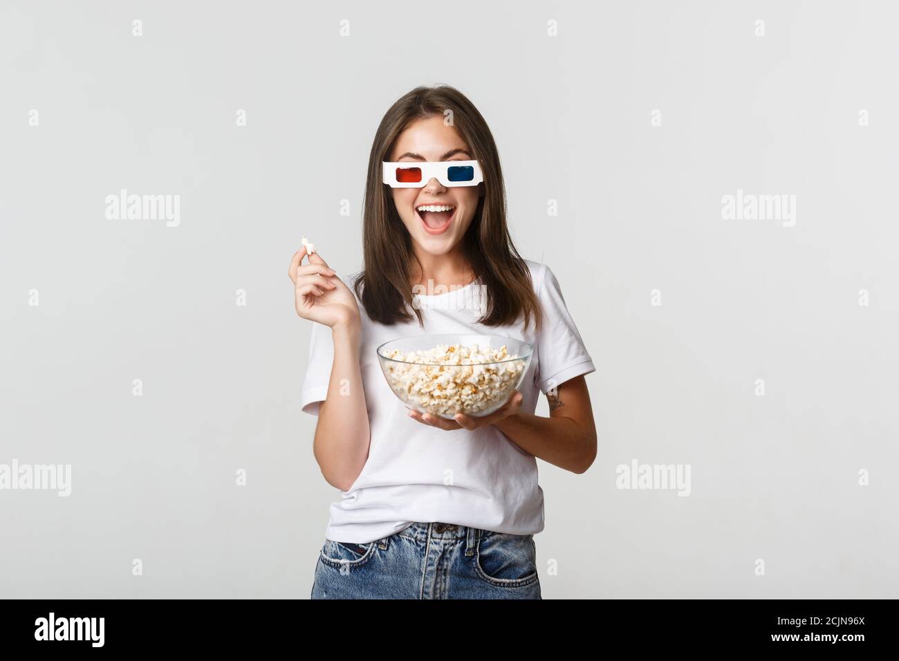 Amused pretty young woman in 3d glasses watching movies or tv series ...
