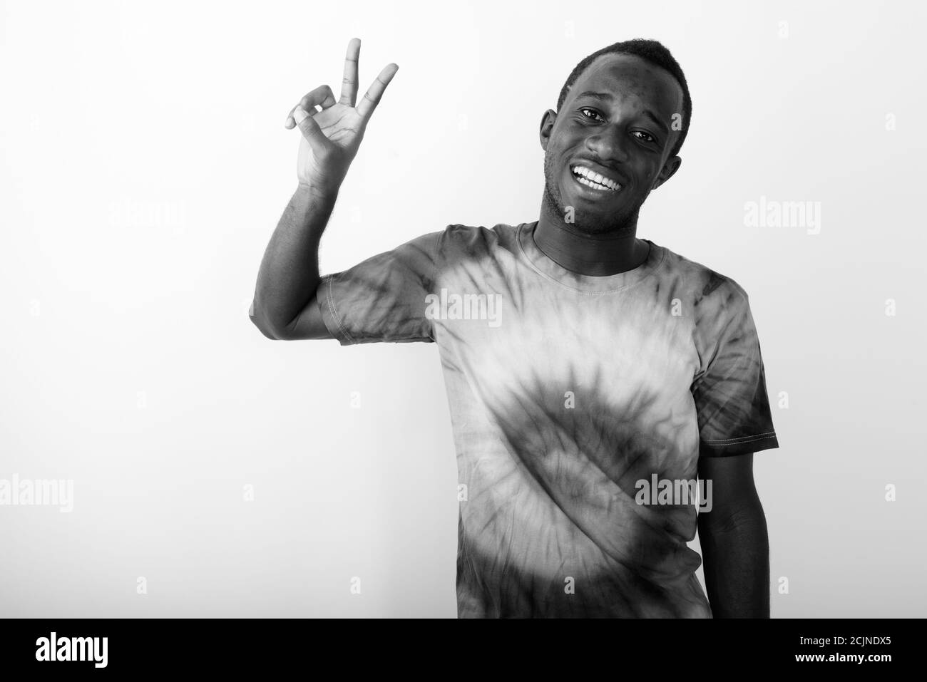 Studio shot of young happy black African man smiling and making peace ...