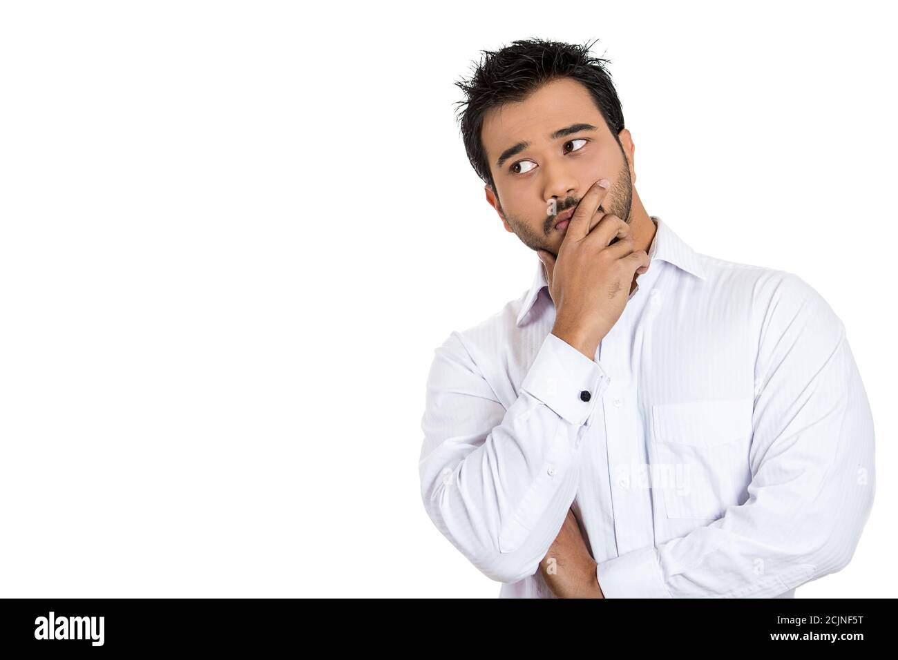 portrait of a young man thinking about something with hand on chin ...