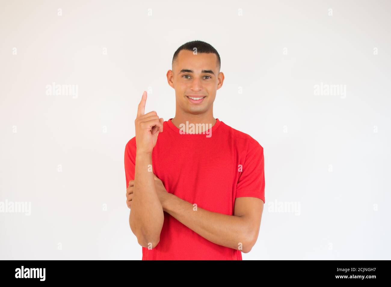 Attractive young man in red shirt pointing up with his finger isolated ...