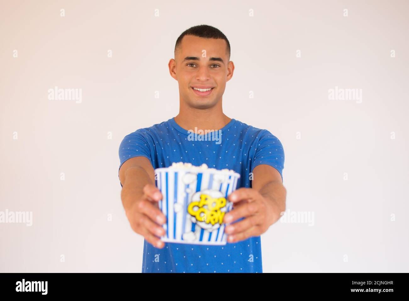 Young man eating popcorn Stock Photo - Alamy