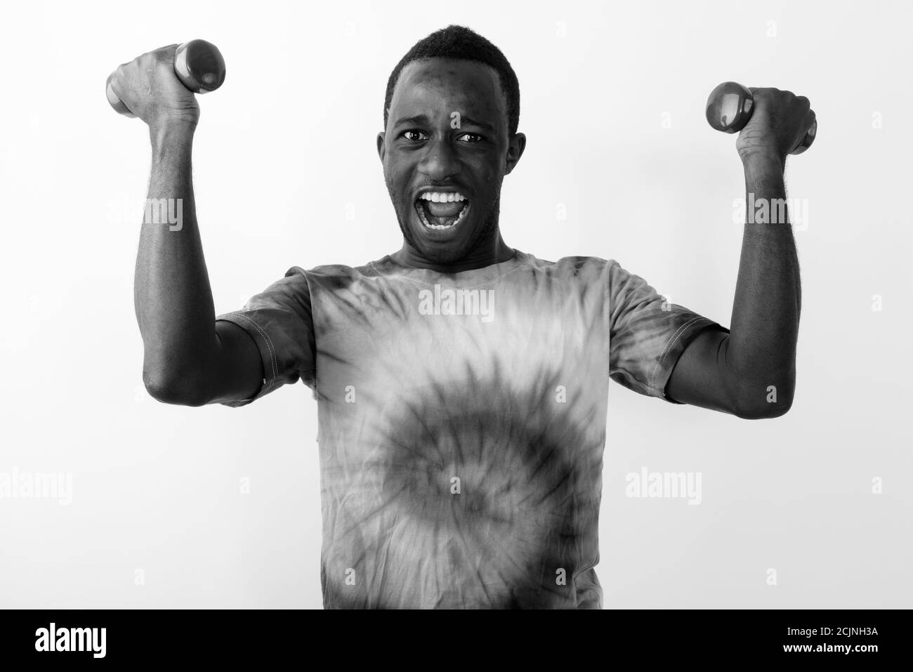 Young African man holding light weight dumbbells and flexing muscles ...