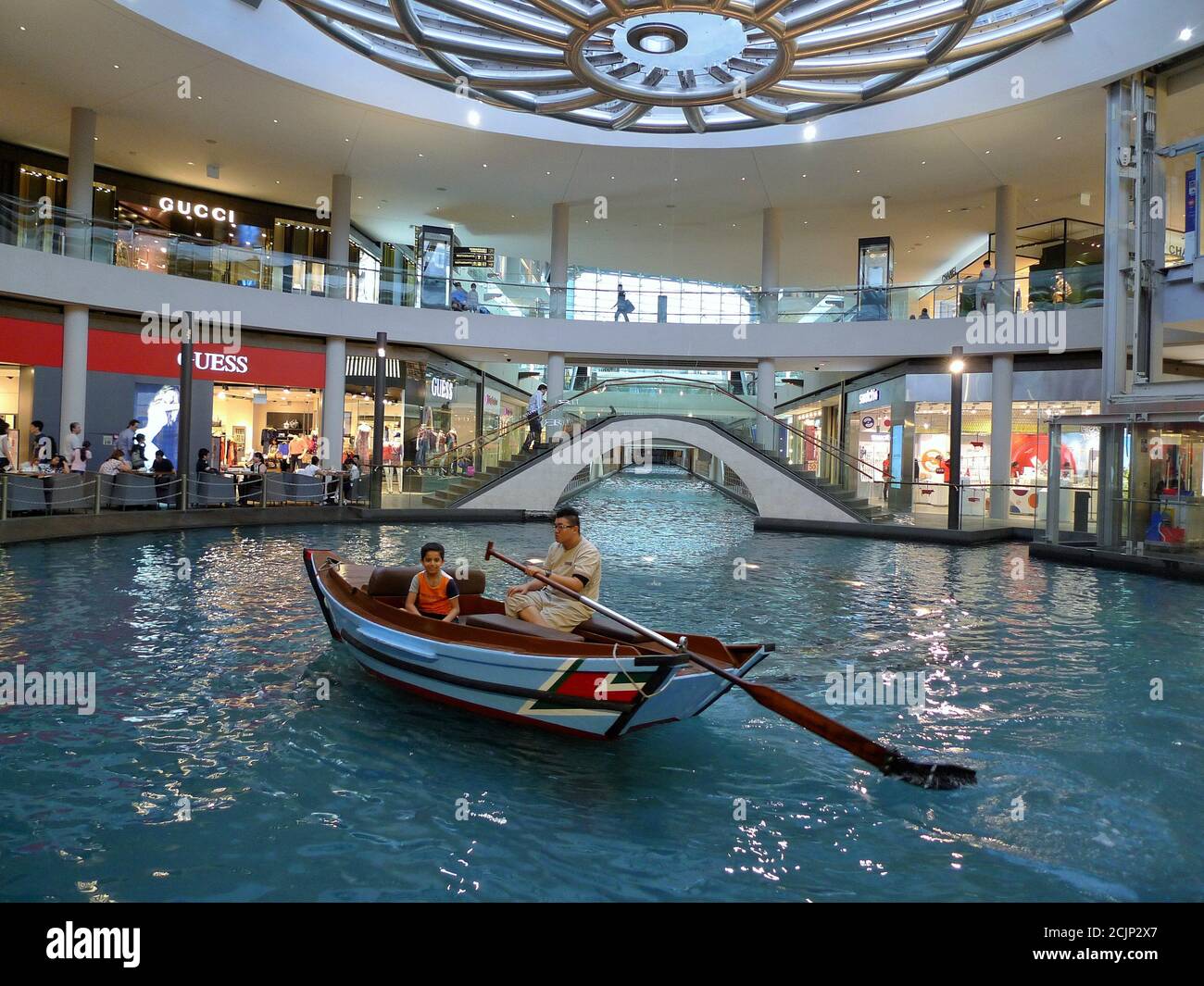 PEOPLE,SHOPS AND A BOAT ALONG A RIVER INSIDE MARINA BAY SHOPPING Stock ...