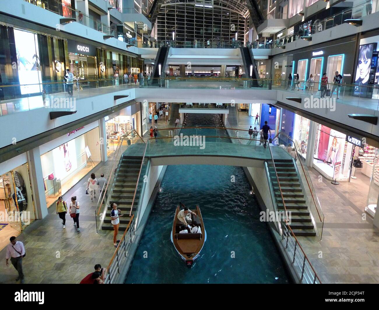PEOPLE,SHOPS AND A BOAT ALONG A RIVER INSIDE MARINA BAY SHOPPING Stock ...