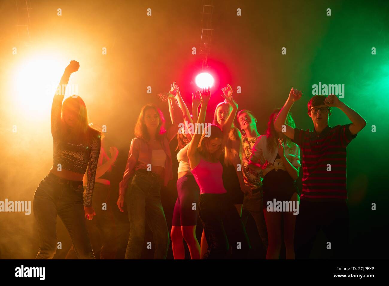 Shadows. A crowd of people in silhouette raises their hands, dancing on ...