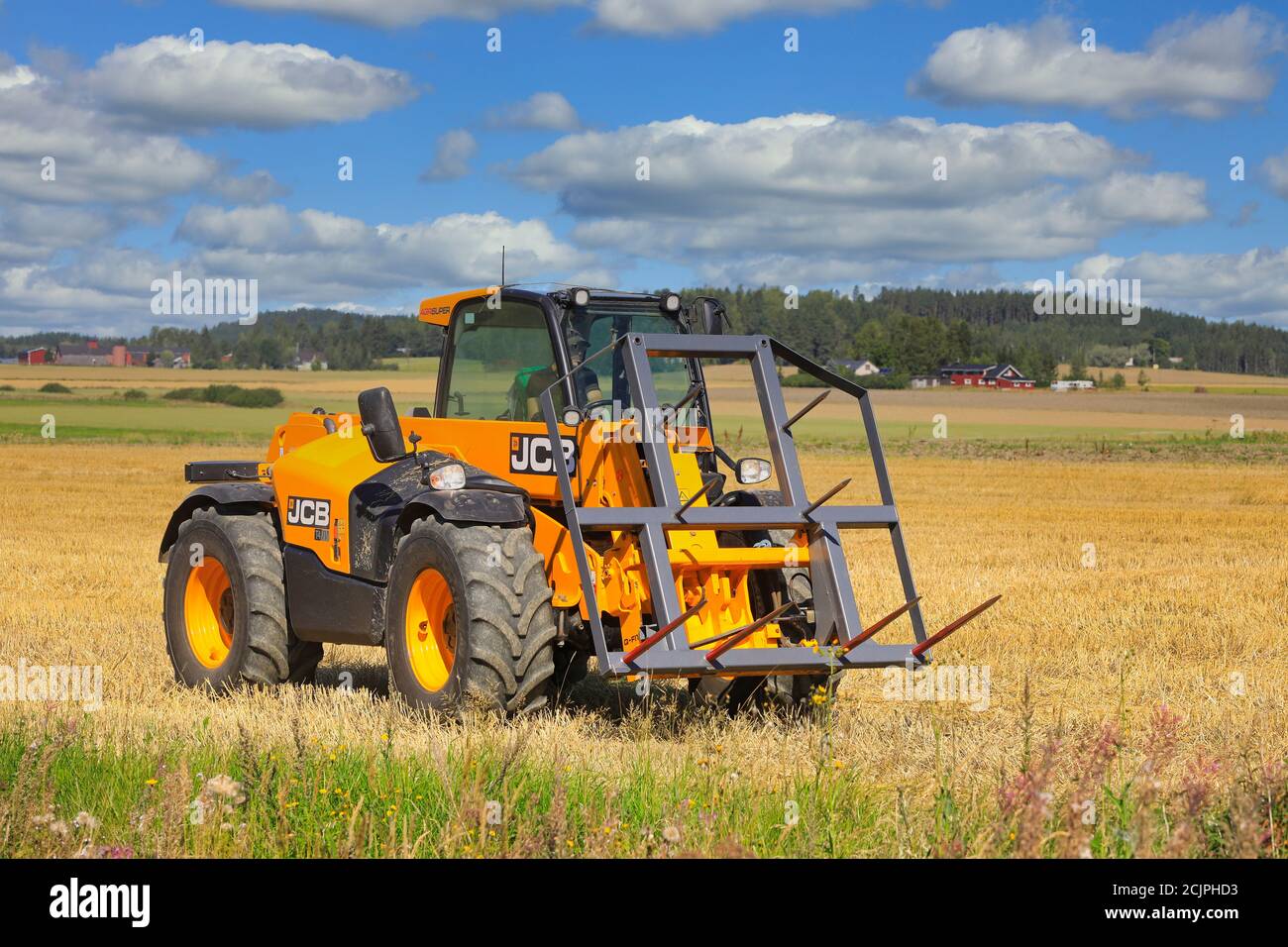 Farmer driving JCB 541-70 Loadall telehandler on farmland to collect ...