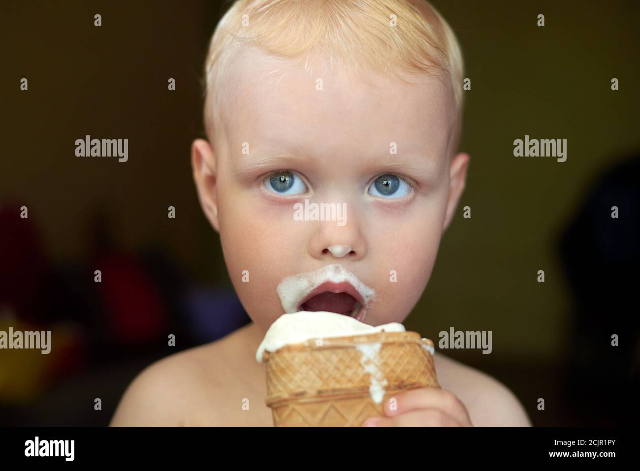 Portrait of a little blue-eyed fair-haired boy eats ice cream Stock ...
