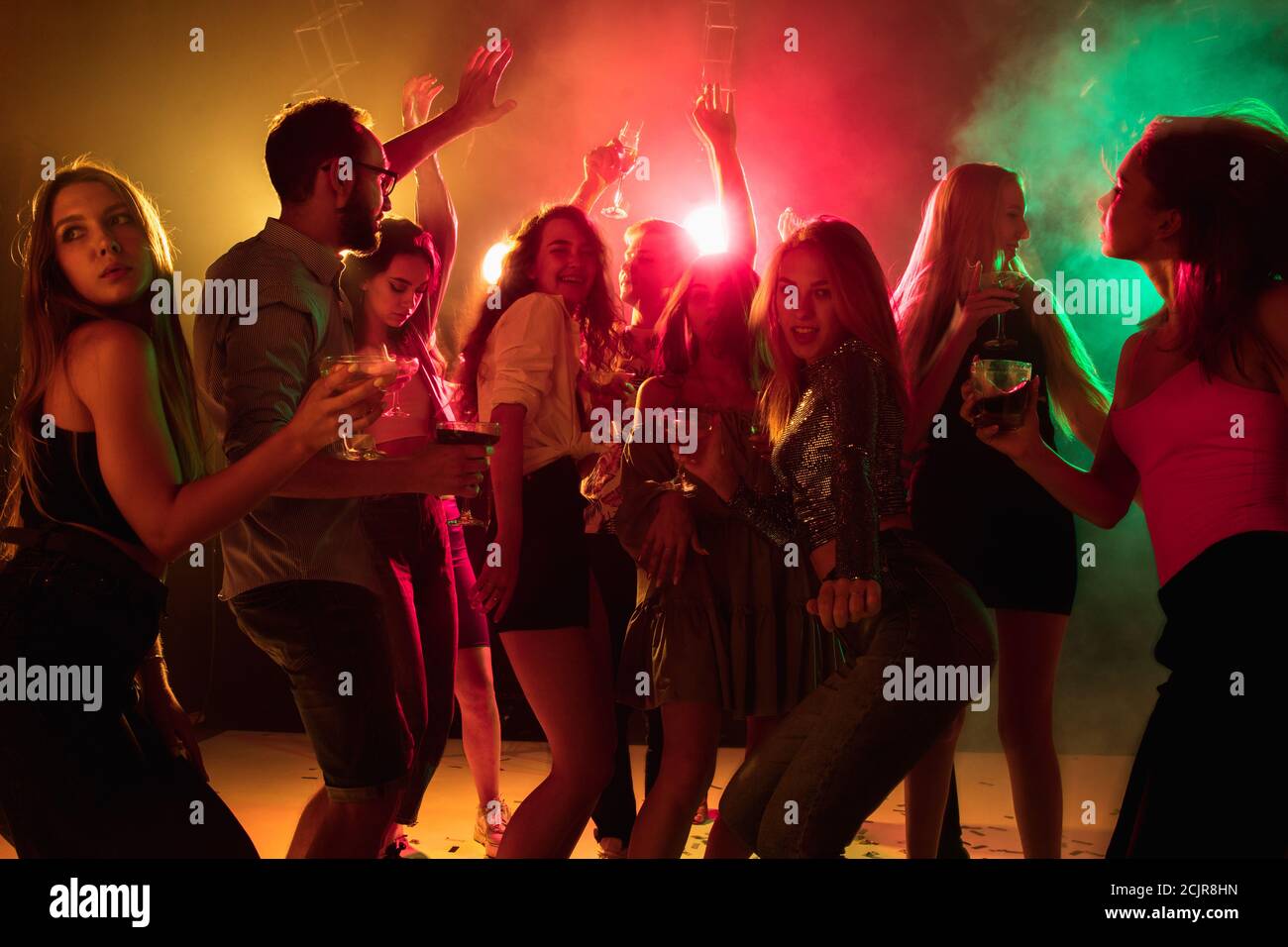 Celebrate. A crowd of people in silhouette raises their hands, dancing ...