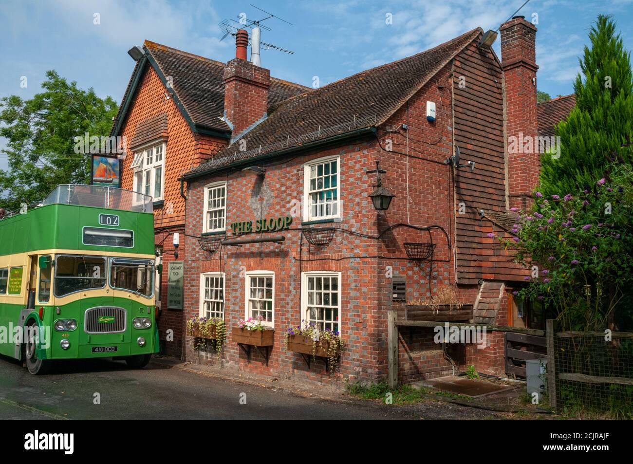 The Sloop Inn pub with an old green double-decker bus parked outside ...