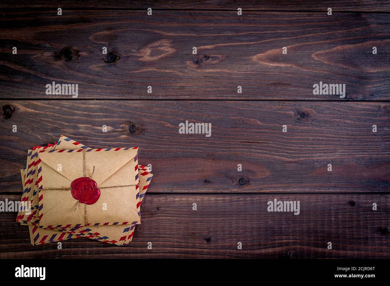 Old letters envelopes with a wax magic stamp triquetra on wooden table ...