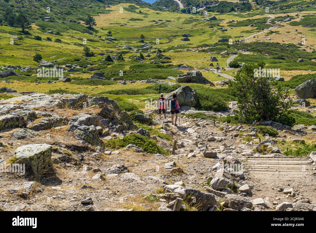 Sunny scenery of travelers walking in a rocky landscape Stock Photo - Alamy