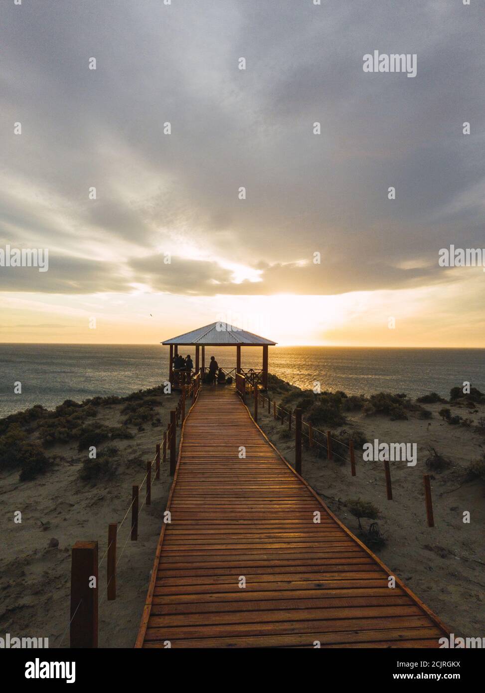 Vertical of a wooden deck on the beach surrounded by the sea during a ...