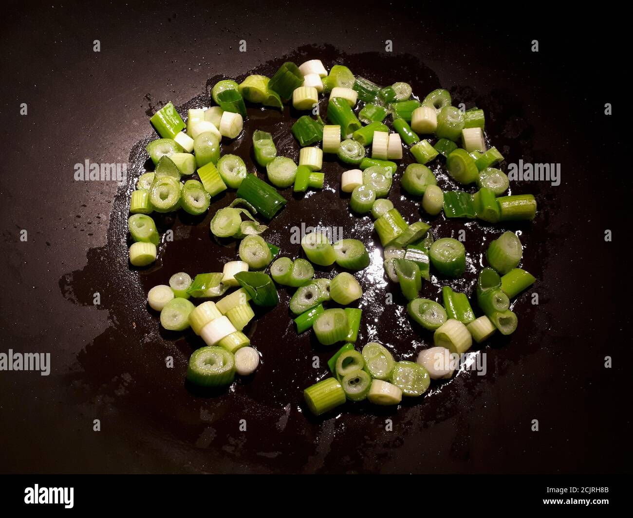 Top view of green onions with oil being cooked in a wok Stock Photo - Alamy