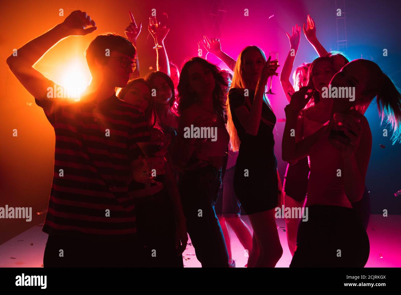 Wild. A crowd of people in silhouette raises their hands, dancing on ...