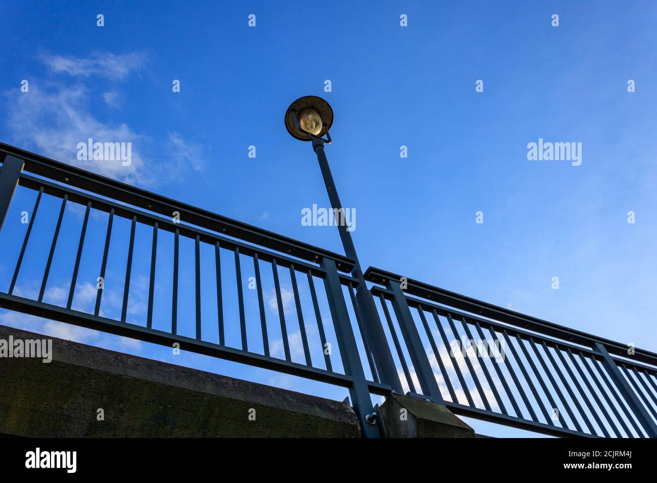 Low angle shot of a street lamp post on an overpass with the blue sky ...