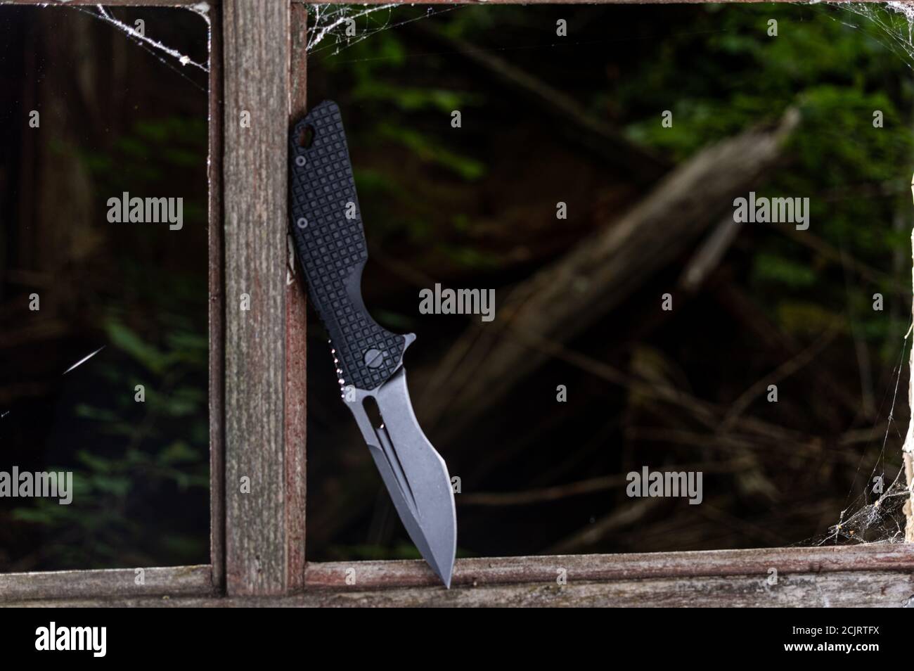 A portrait of a folding knife. Knife in a window frame Stock Photo - Alamy