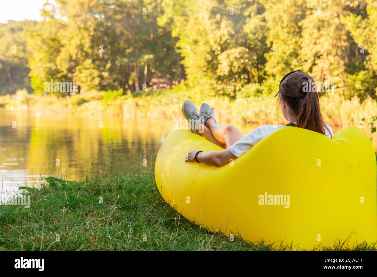 woman laying down relaxing on air sofa at lake beach Stock Photo - Alamy