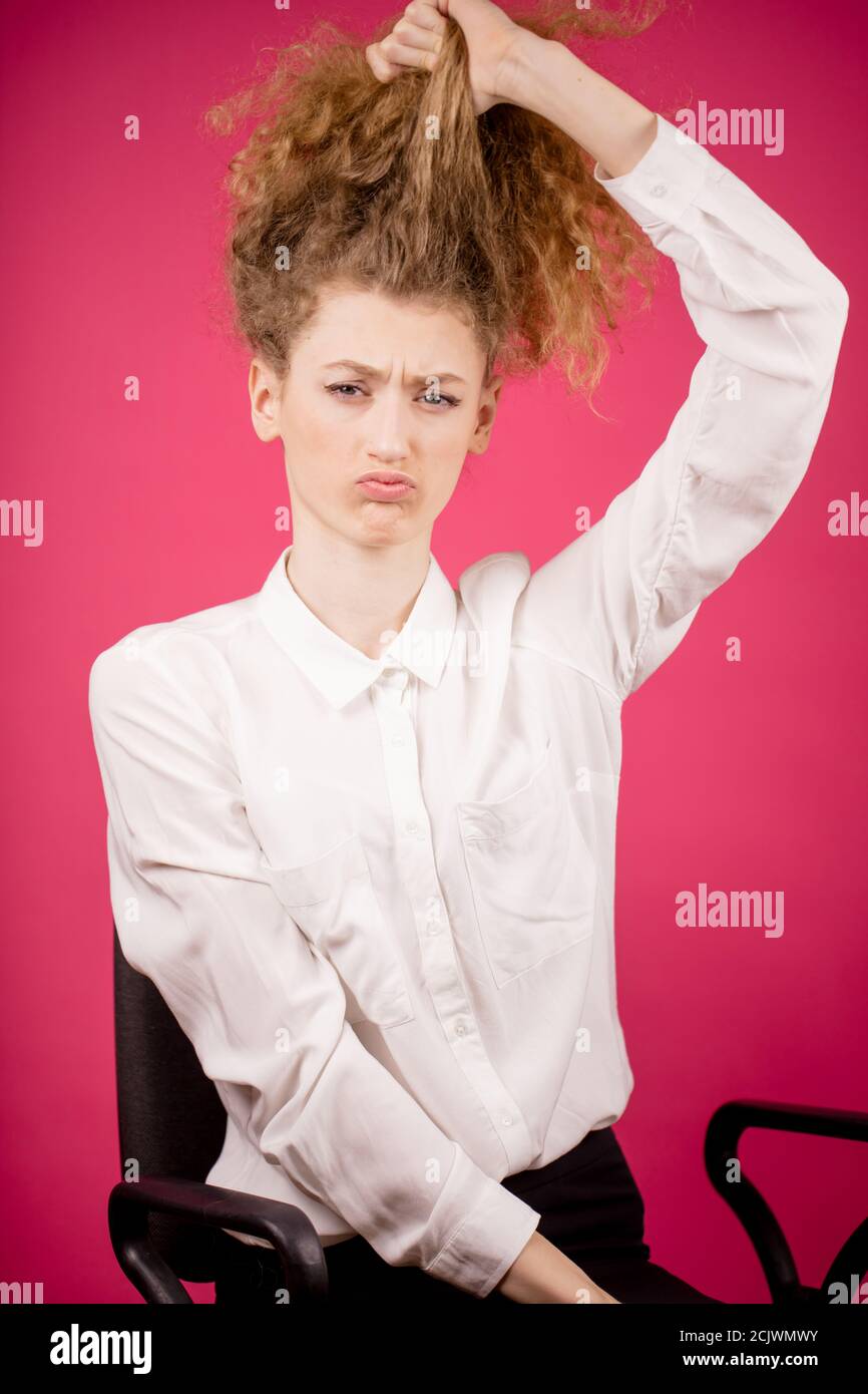 frawning woman touching her unmangeable fragile hair. fractured hair ...