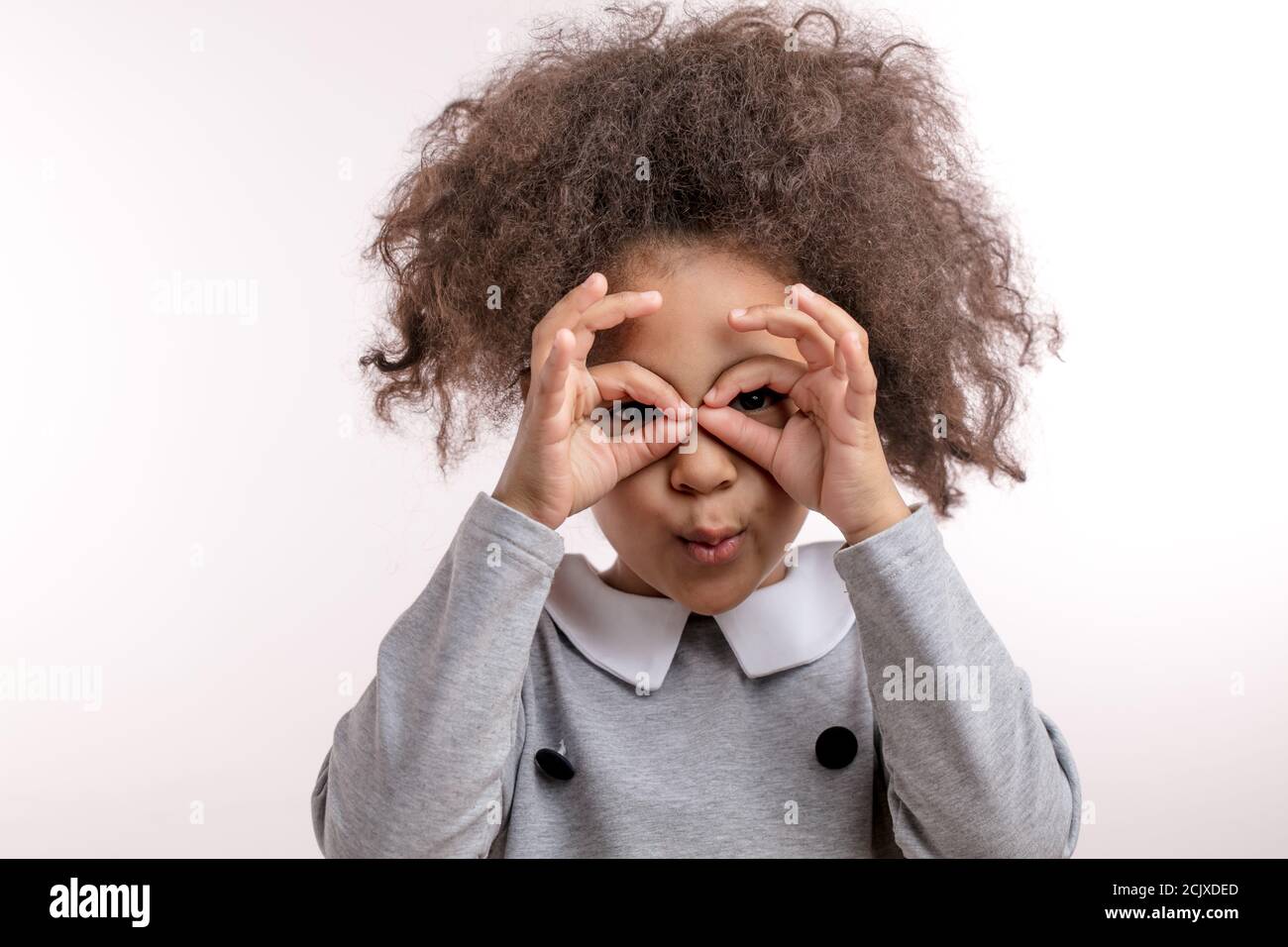 joyful kid with funny hair is looking through the fake glasses. have ...