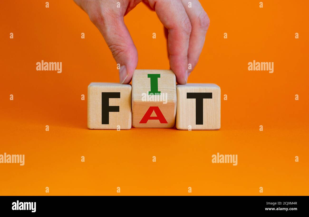 Hand turns a cube and changes the word fat to fit. Beautiful orange ...
