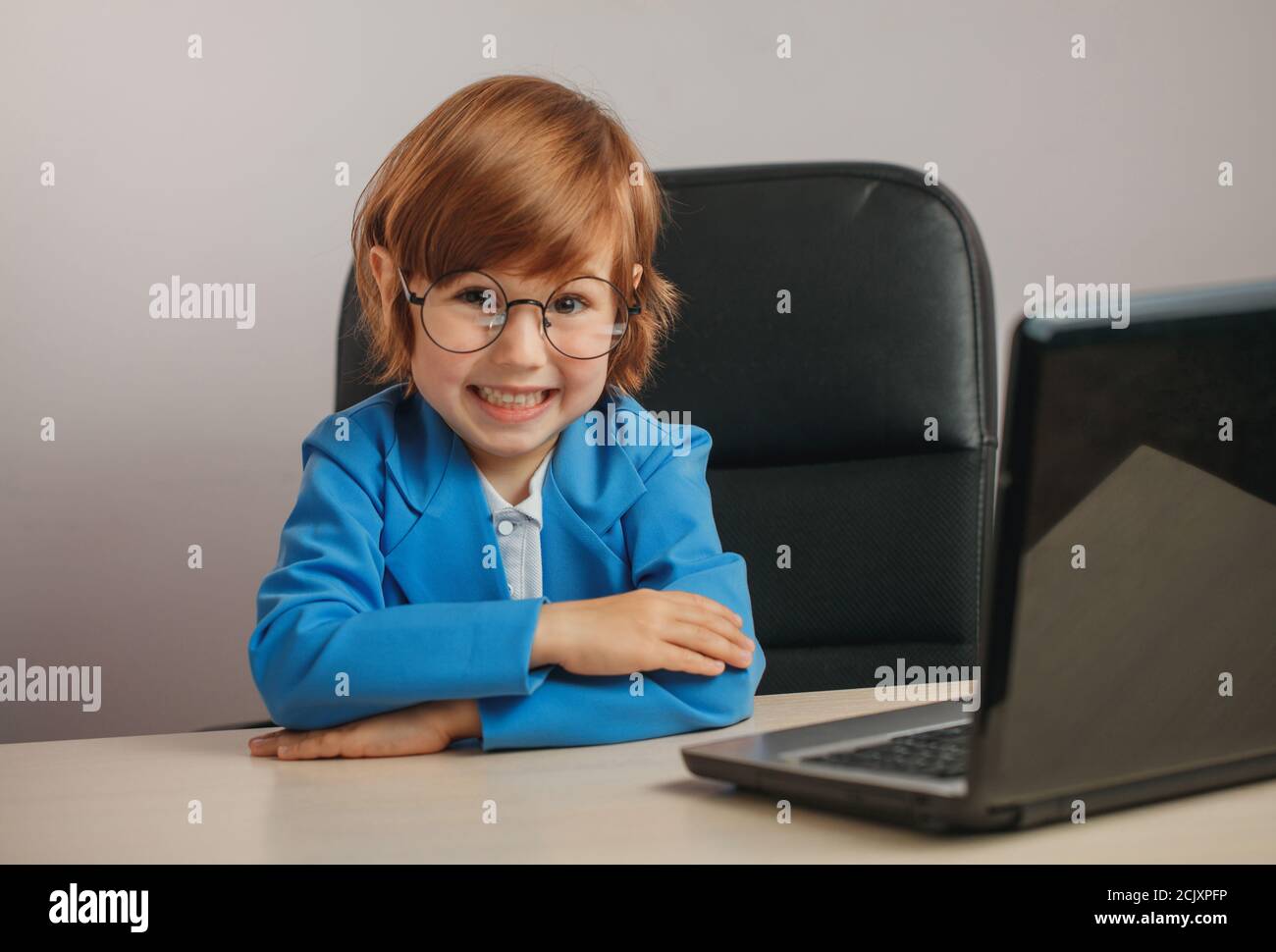good pupil in glasses is holding his arms on the desk. education ...