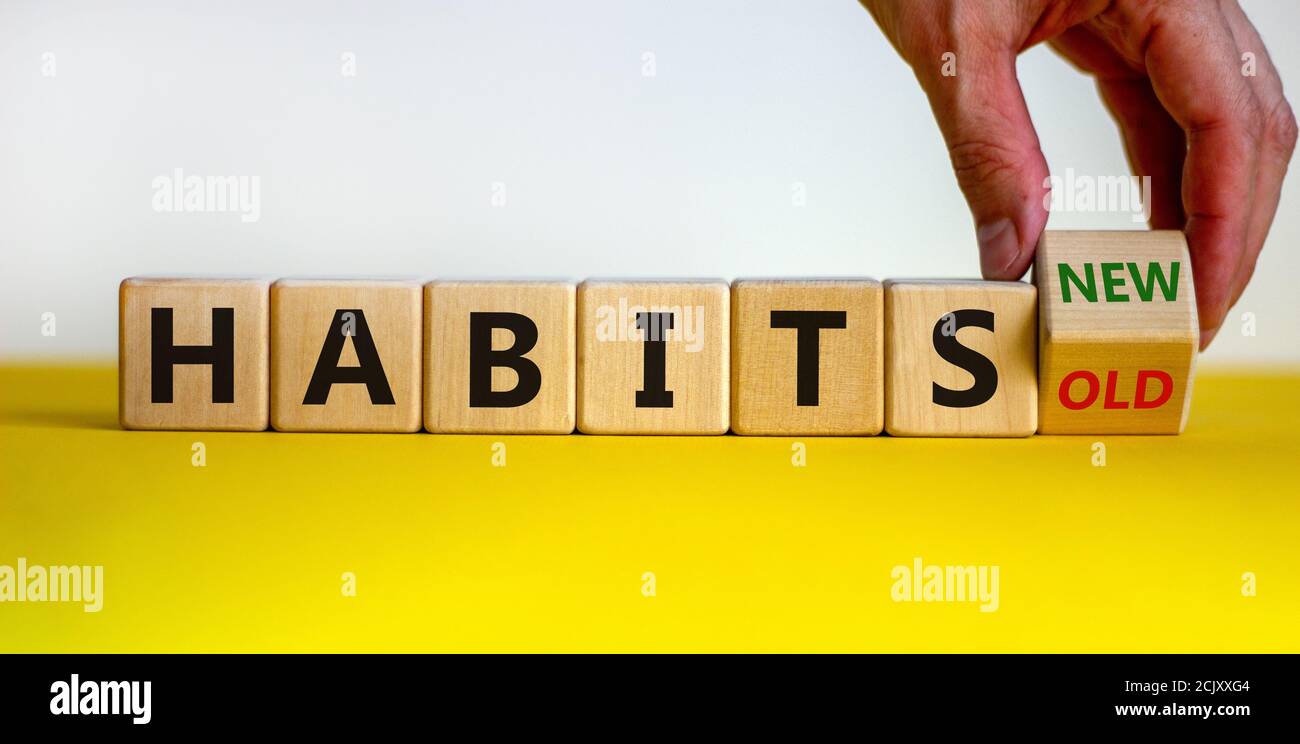 Male hand turning a cube and changes the expression 'old habits' to ...