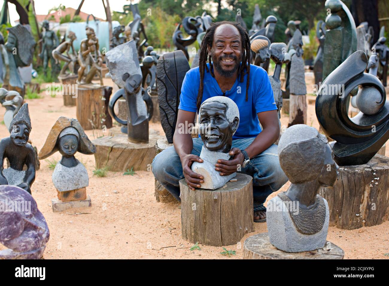 Zimbabwean soap stone scultor at market Stock Photo - Alamy