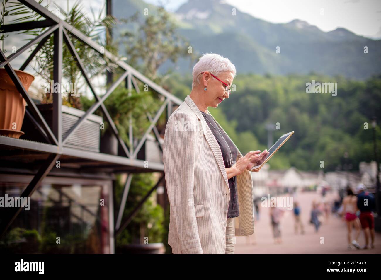 an attractive reach housekeeper is working on the tablet in the street ...