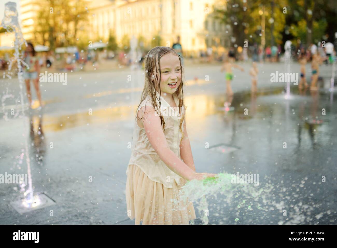 Cute young girl playing in fountains on newly renovated Lukiskes Square ...