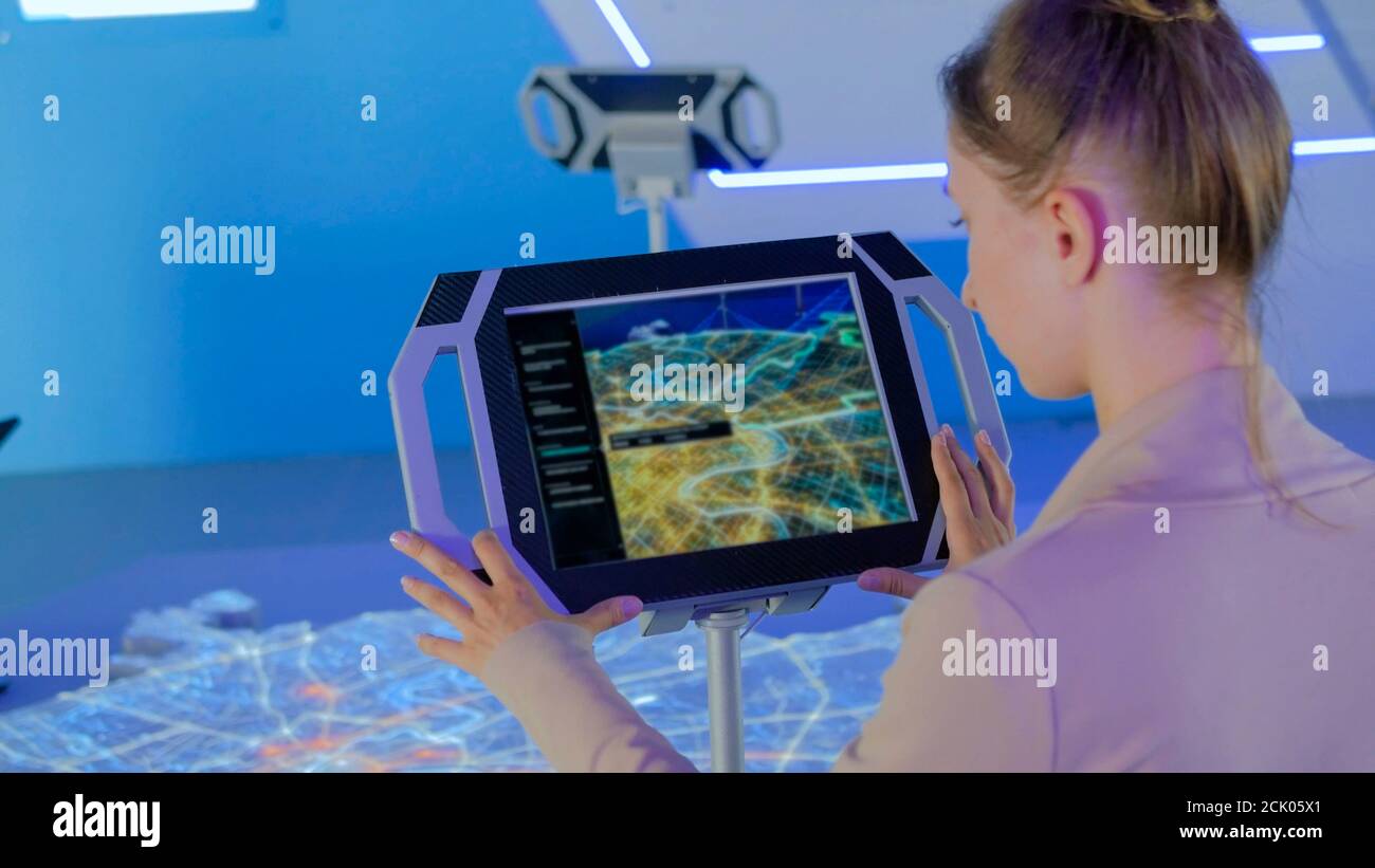 Woman using interactive touchscreen display with virtual map of Moscow ...
