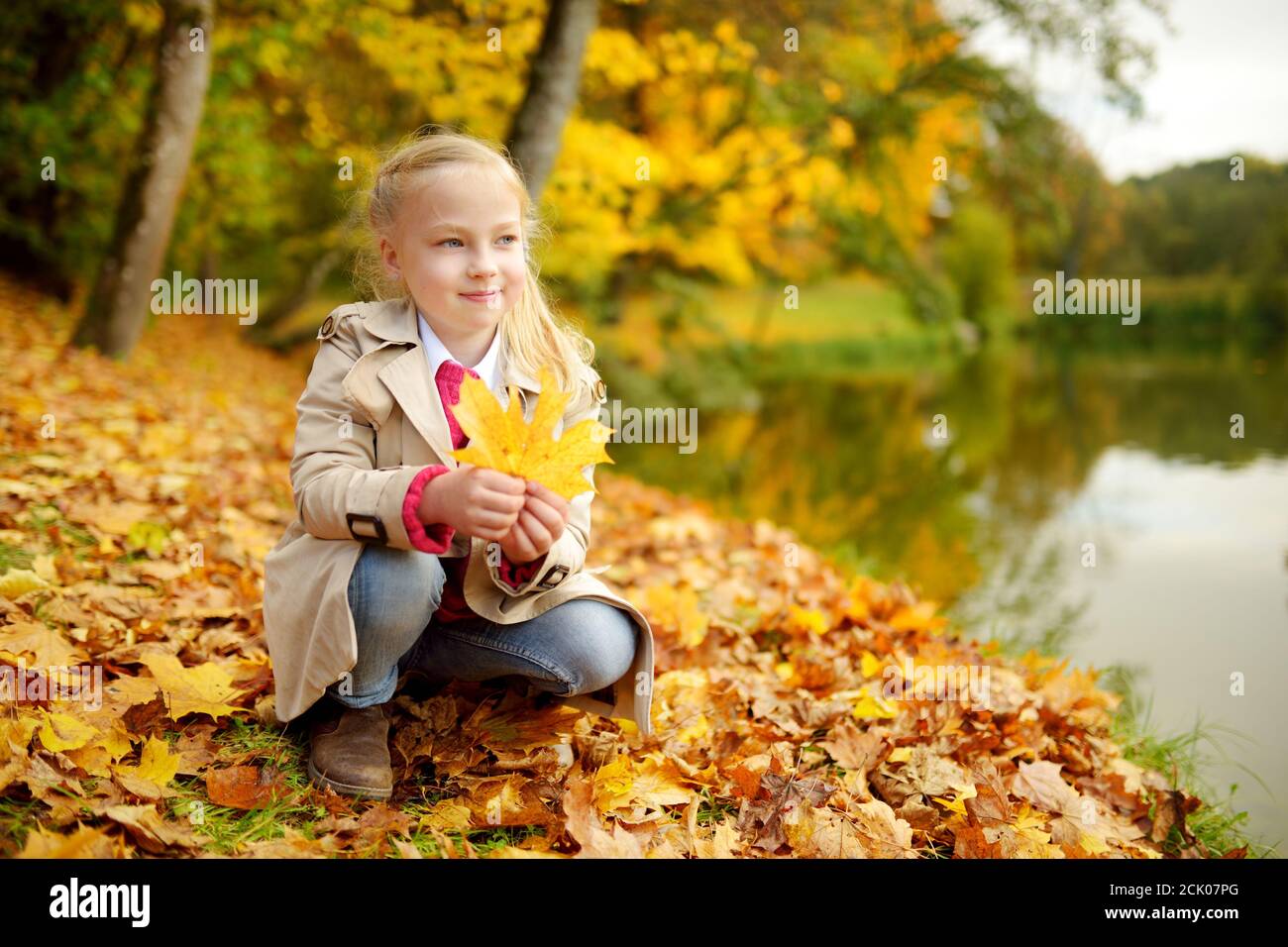 Adorable young girl having fun on beautiful autumn day. Happy child ...