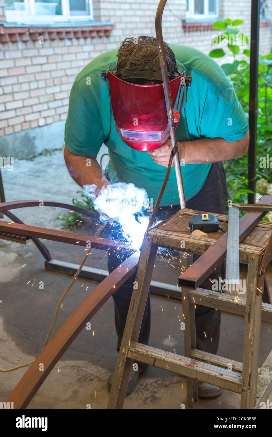 Human working of welding. Lights, manual. welder is welding metal part ...
