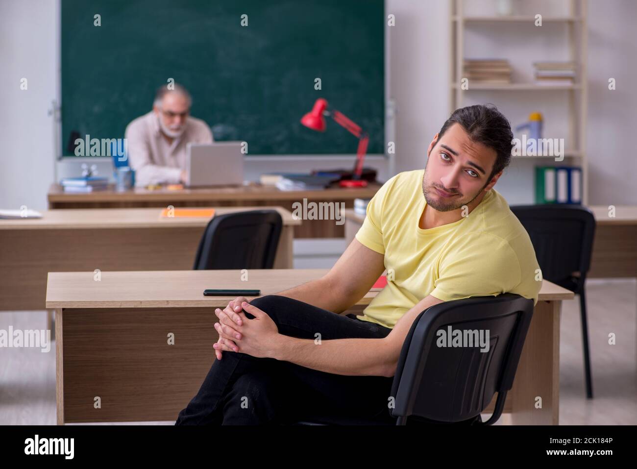 Old teacher and young student in the classroom Stock Photo - Alamy
