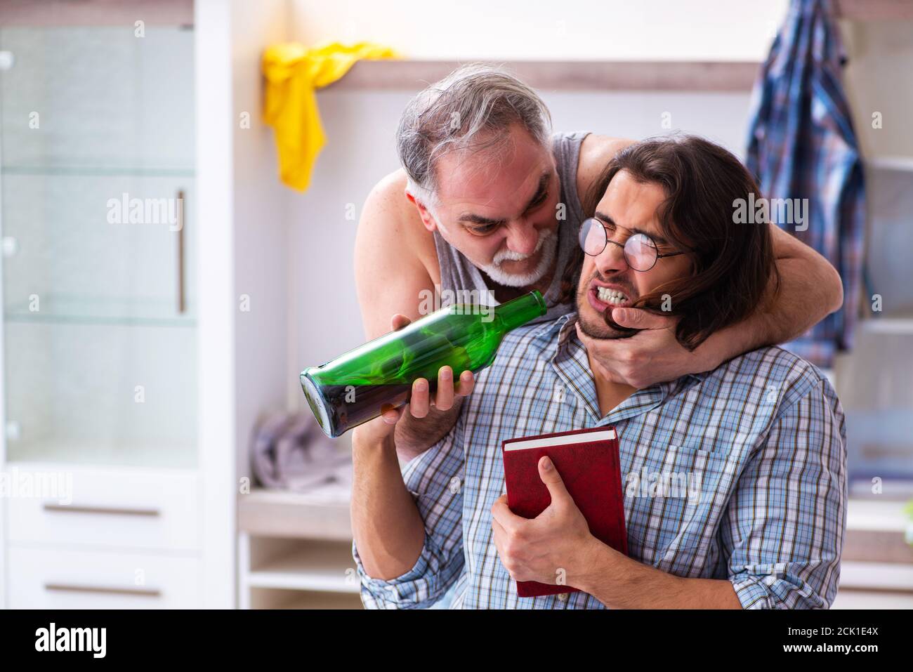 Young son student and dad alcoholic at home Stock Photo - Alamy