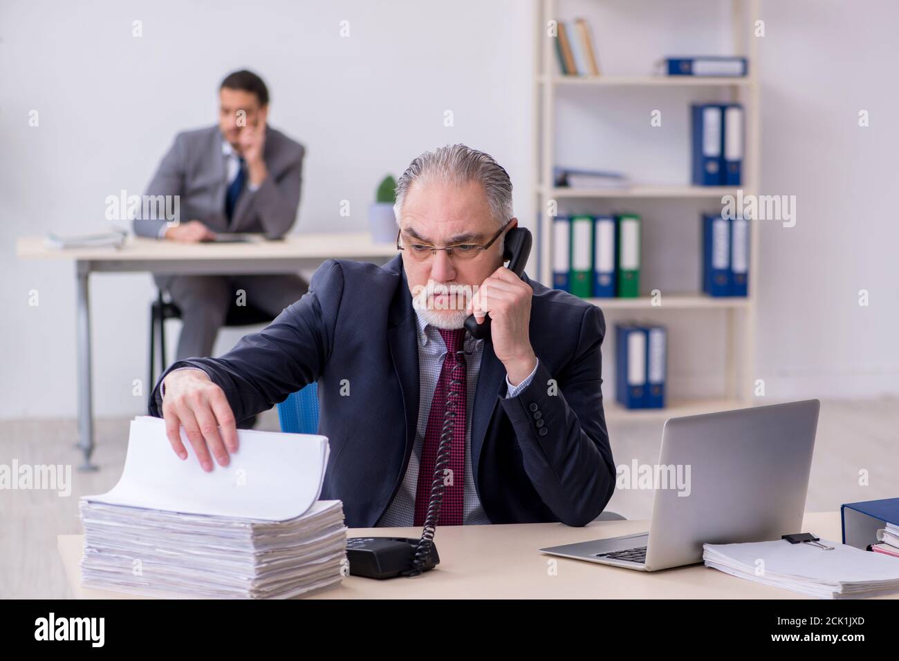 Old boss and his assistant working in the office Stock Photo - Alamy