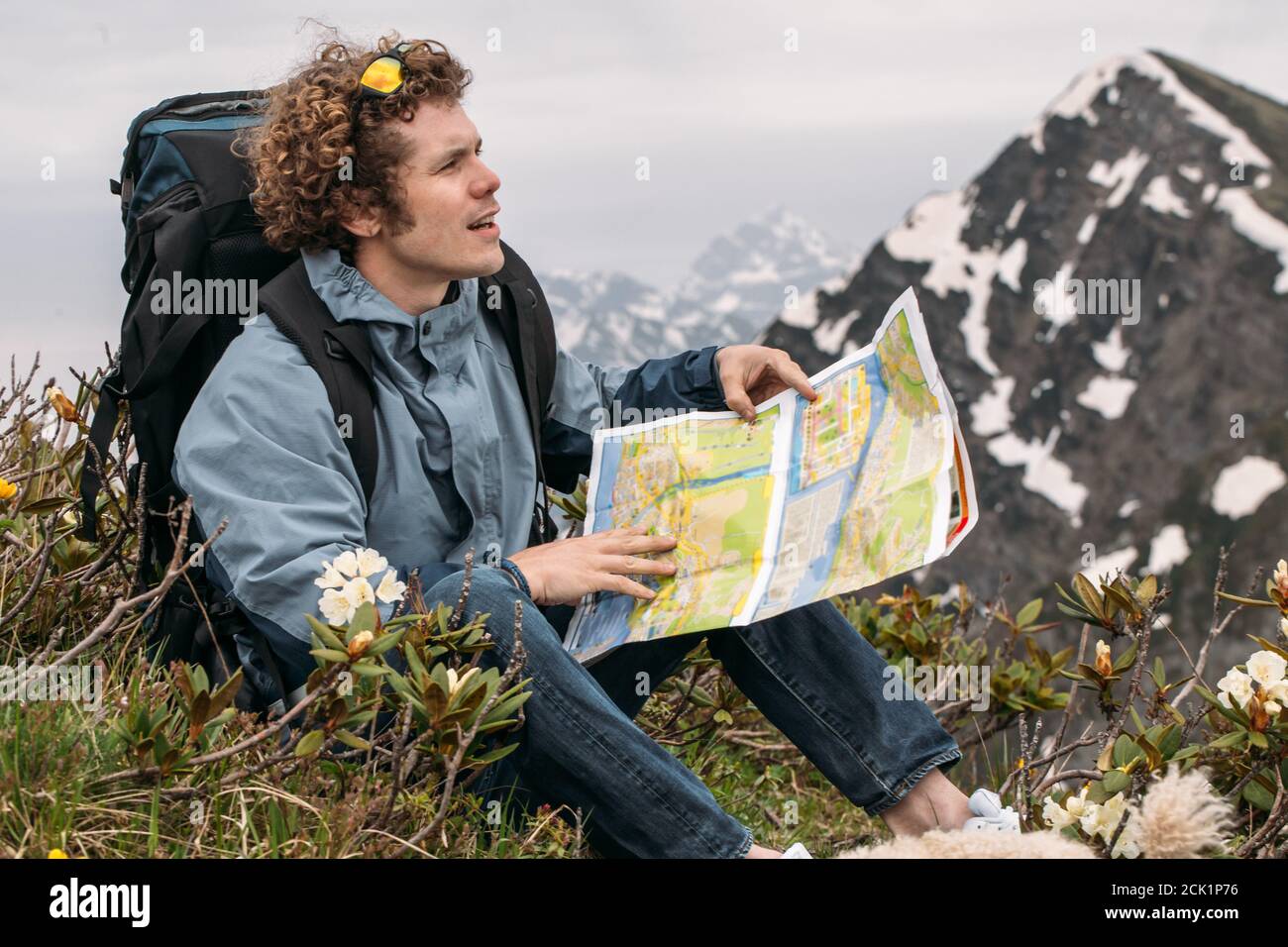 close up side view photo of a backpacker with map on the hill with ...