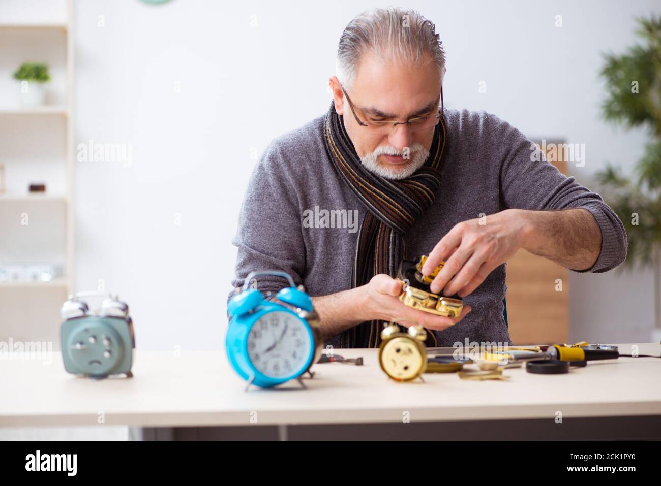 Old watchmaker working in the workshop Stock Photo - Alamy