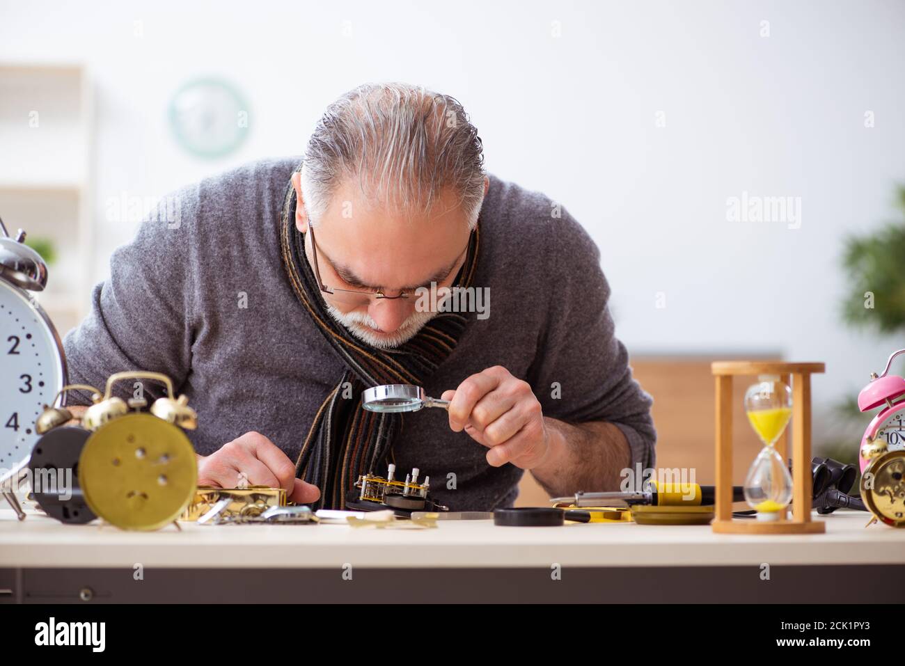 Old watchmaker working in the workshop Stock Photo - Alamy