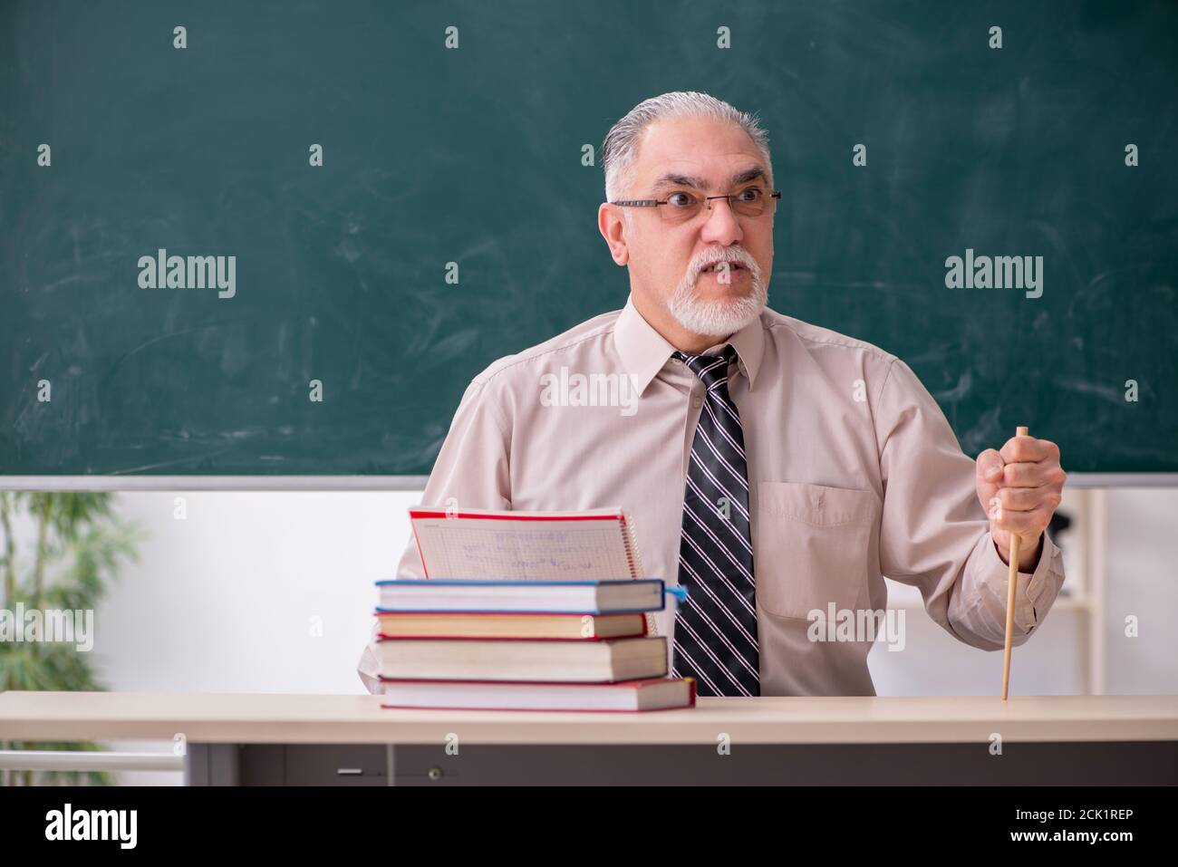 Old experienced teacher in the classroom Stock Photo - Alamy