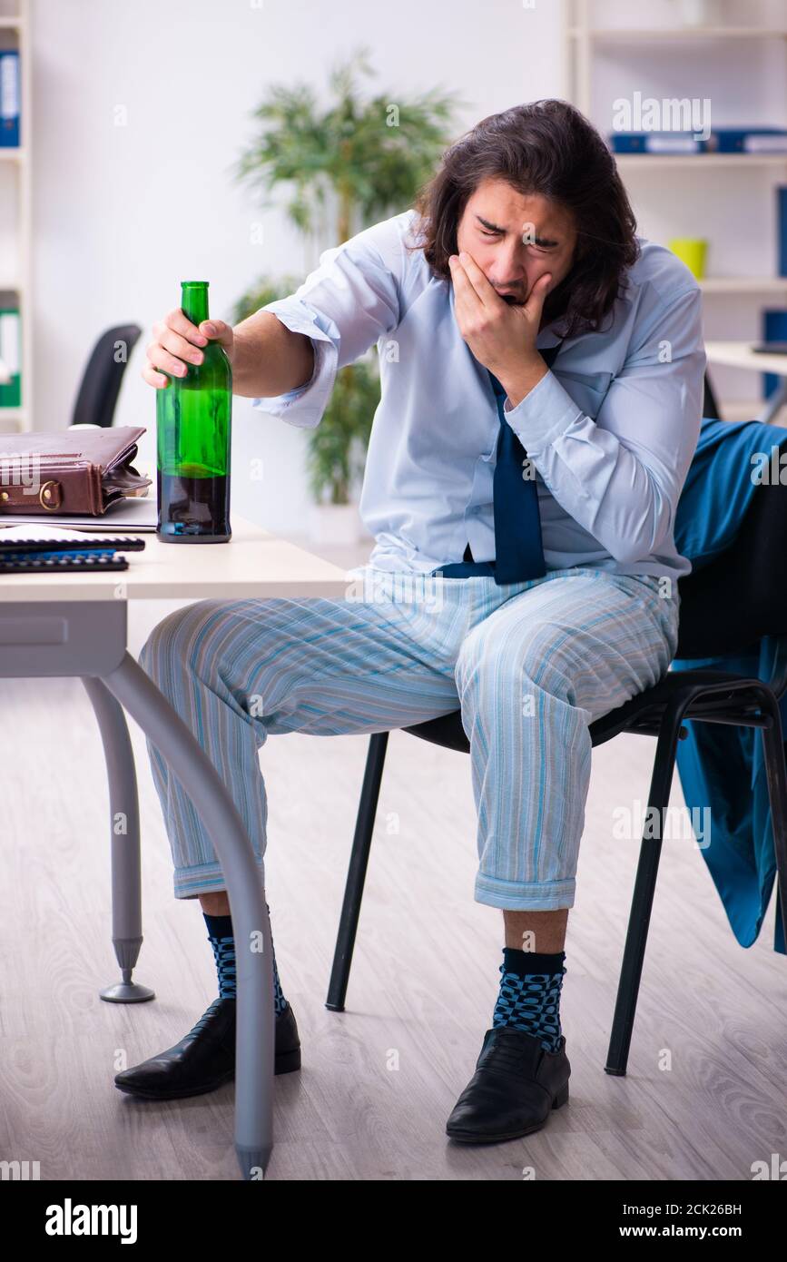 Male employee coming to work after the party Stock Photo - Alamy