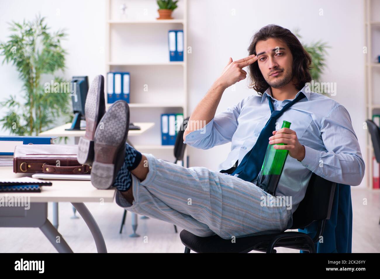 Male employee coming to work after the party Stock Photo - Alamy