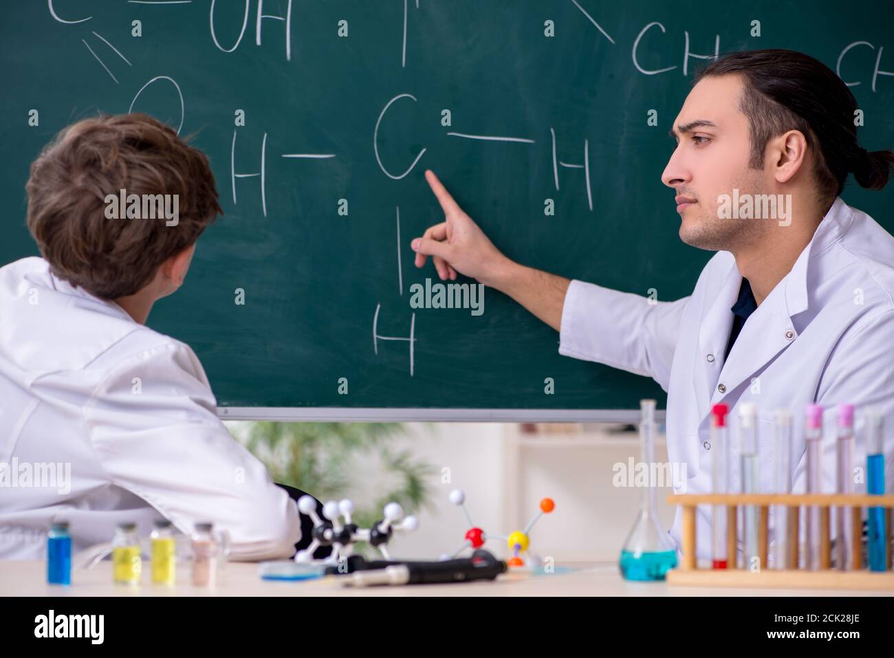Young chemistry teacher and schoolboy in classroom Stock Photo - Alamy