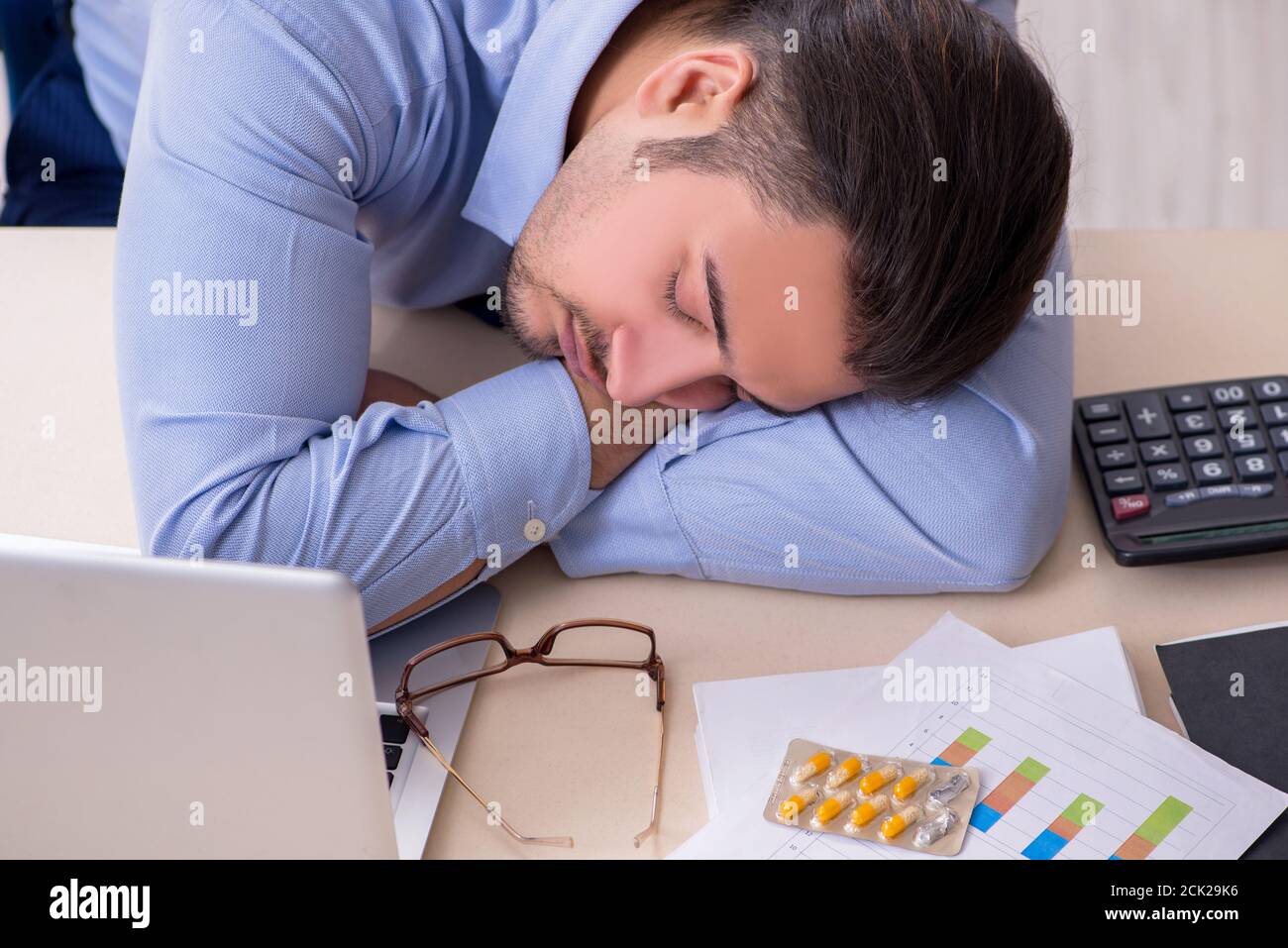 Sick male employee suffering at the workplace Stock Photo - Alamy