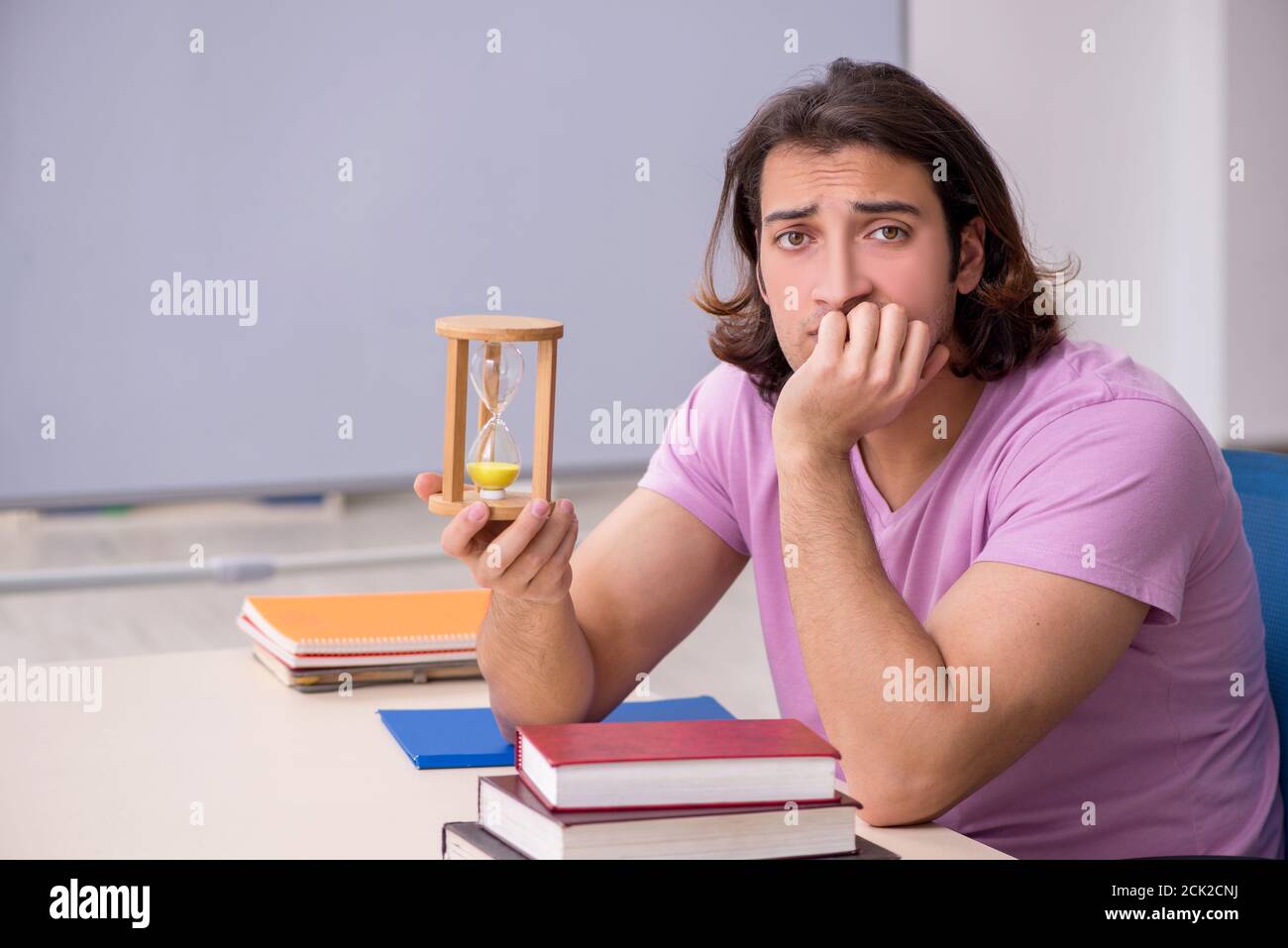 Young student in the classroom at time management concept Stock Photo ...