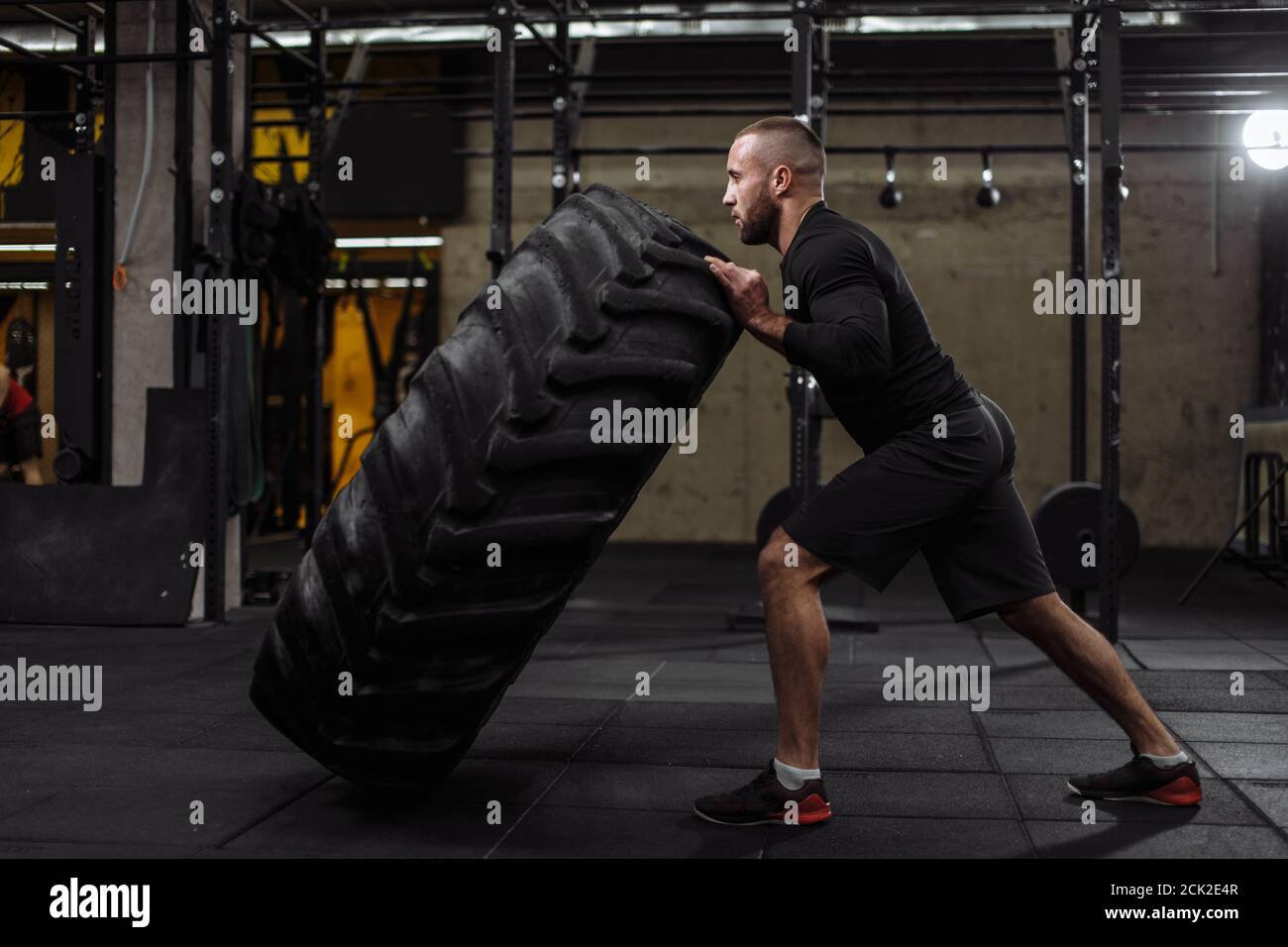 physical exercises with tire, heavy things. side view full length photo ...