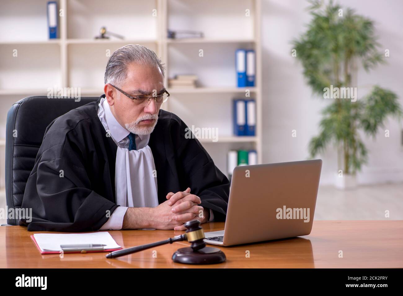 Old male judge working in the courthouse Stock Photo - Alamy