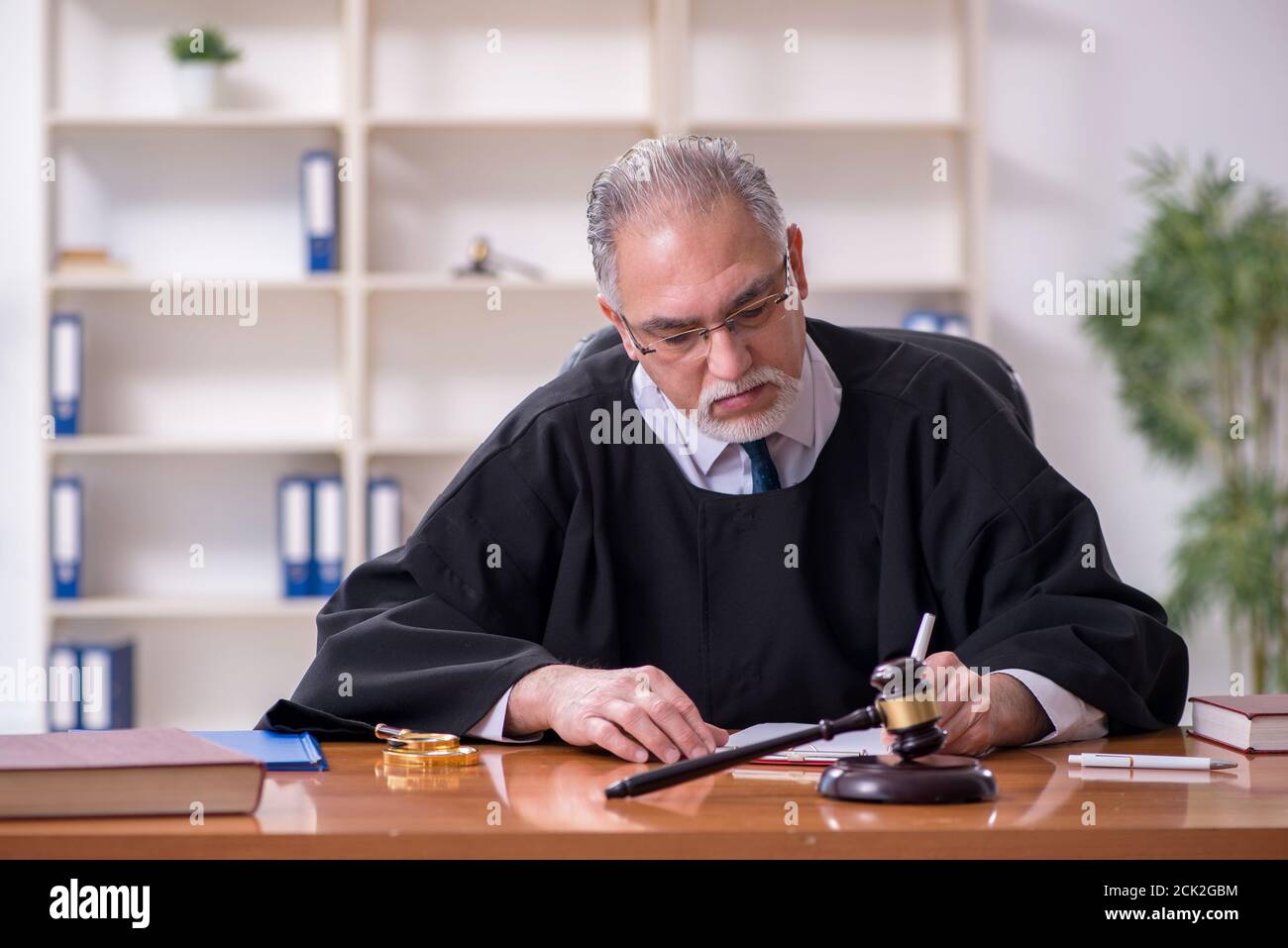 Old male judge working in the courthouse Stock Photo - Alamy